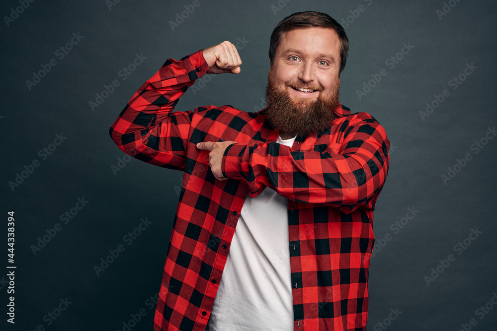 Sassy confident smiling macho man with big muscles, proudly pointing ...