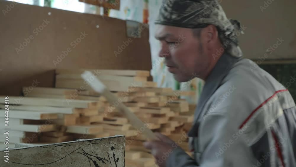 A worker is dealing with the lumber gluing process at the Factory. A ...