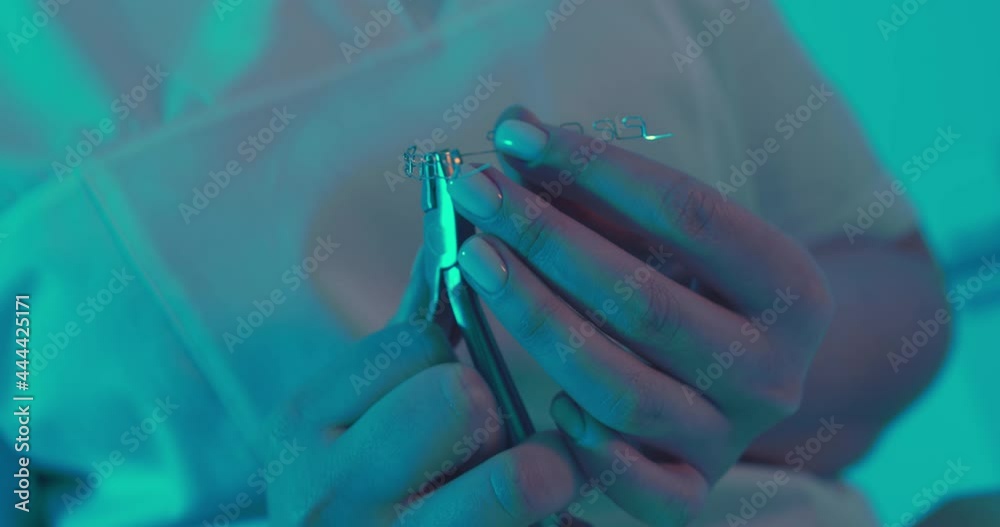 Close-up multiloop edgewise archwire is holding in the hand a female ...