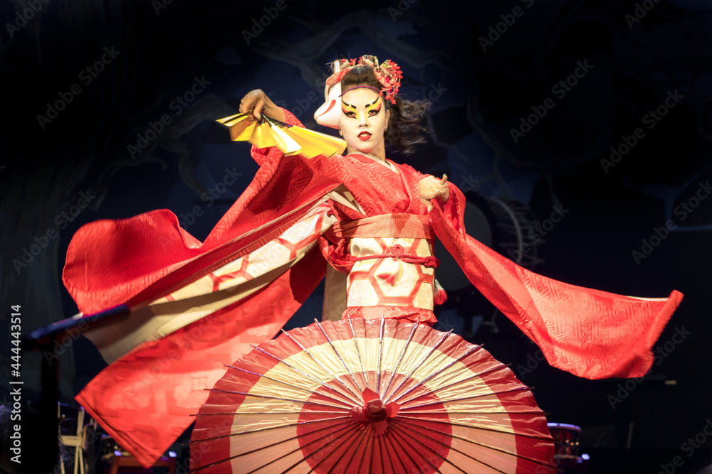 Woman dances with a fan and umbrella, with flowing sleeves. Traditional ...