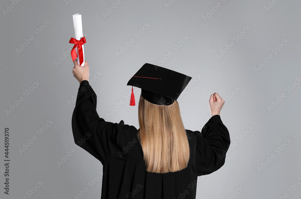 Student with diploma on grey background, back view Stock Photo | Adobe ...