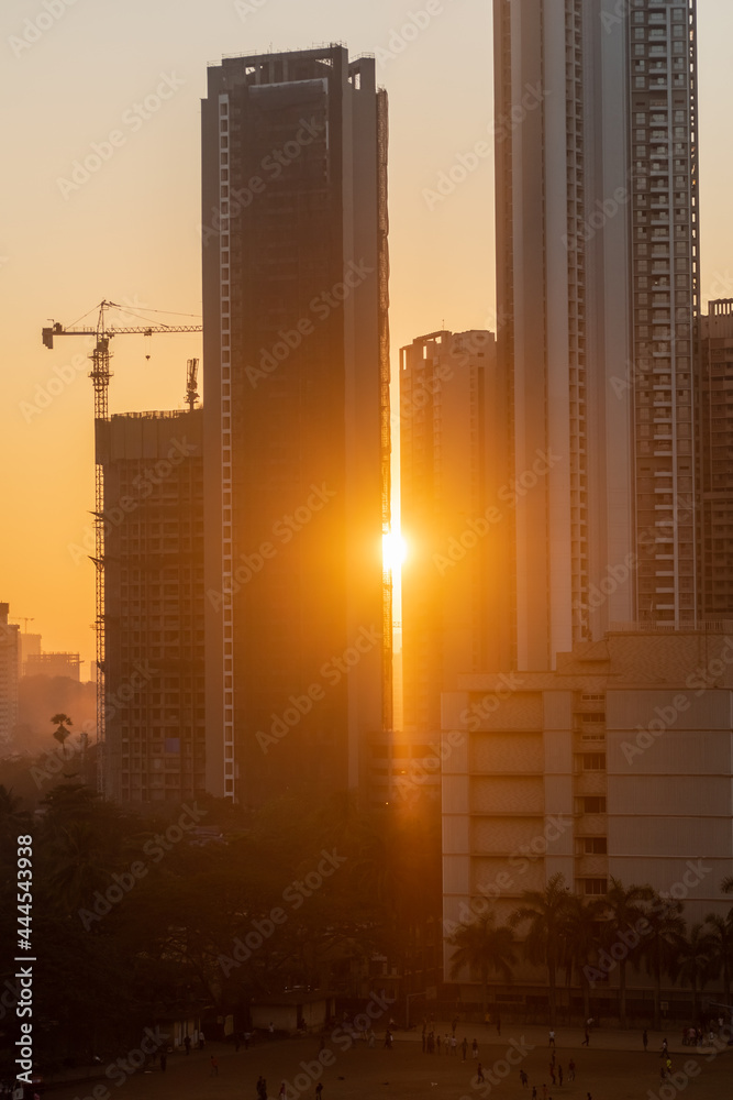Sun setting behind high rise skyscrapers under construction in the ...