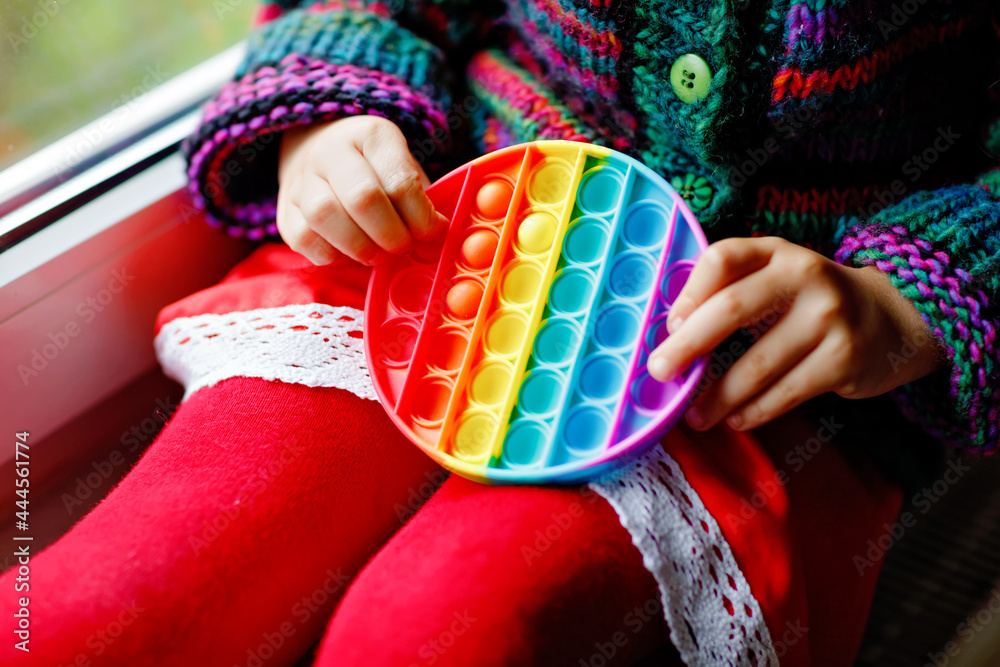 Little blonde preschool girl playing with new trend sensory toy ...