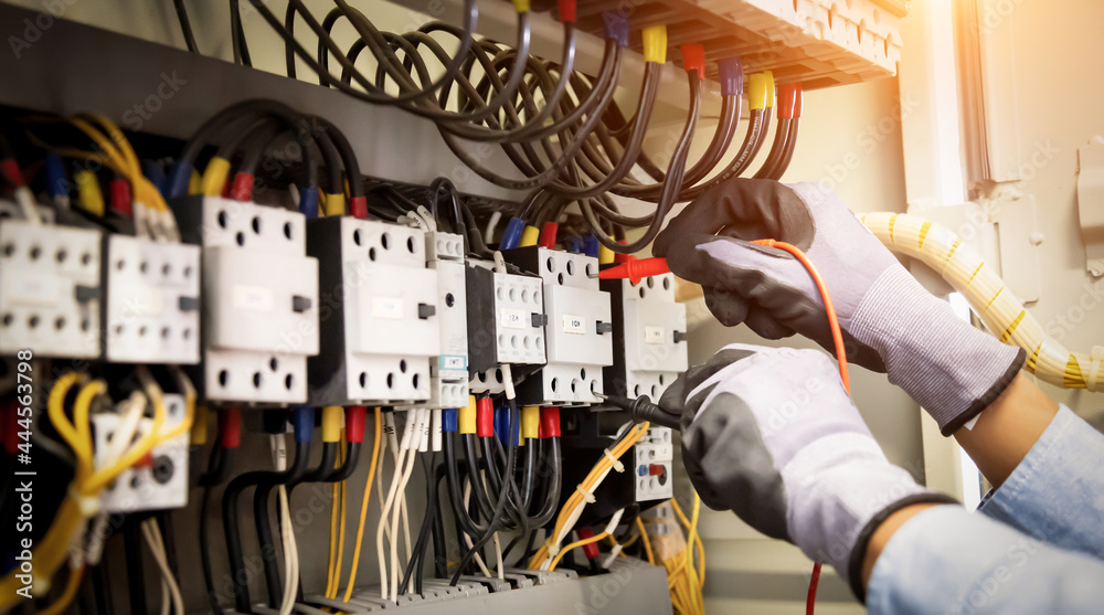 Electrical engineer using digital multi-meter measuring equipment to ...