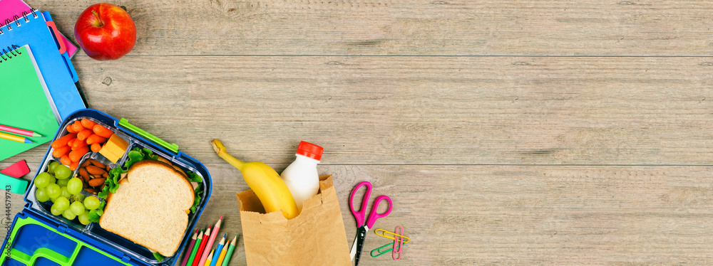 Healthy school lunch and school supplies. Corner border, top view on a ...