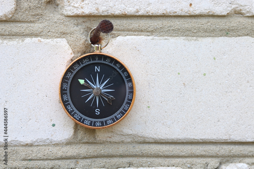 Classic navigation compass on brick wall background as symbol of ...