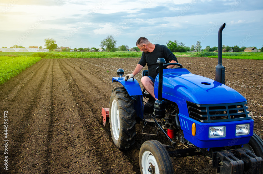 A farmer is cultivating a farm field. Preparatory earthworks before ...