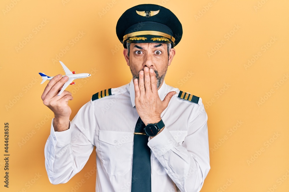 Handsome middle age man with grey hair wearing airplane pilot uniform ...