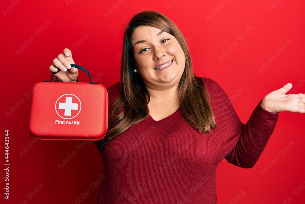 Beautiful brunette plus size woman holding first aid kit celebrating ...