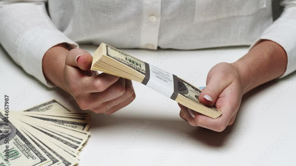 Businessman flipping through the bills in a bundle of money, rich man ...