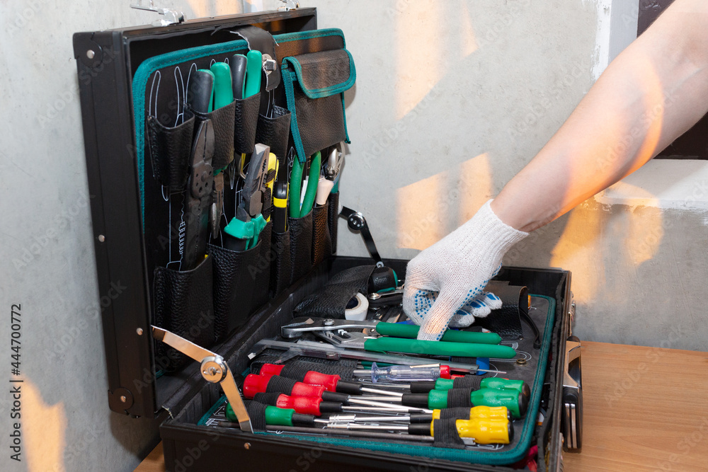 Foto de Mechanic opens a toolbox. Repair tool kit. Mechanic chooses a tool for work. Man takes ...