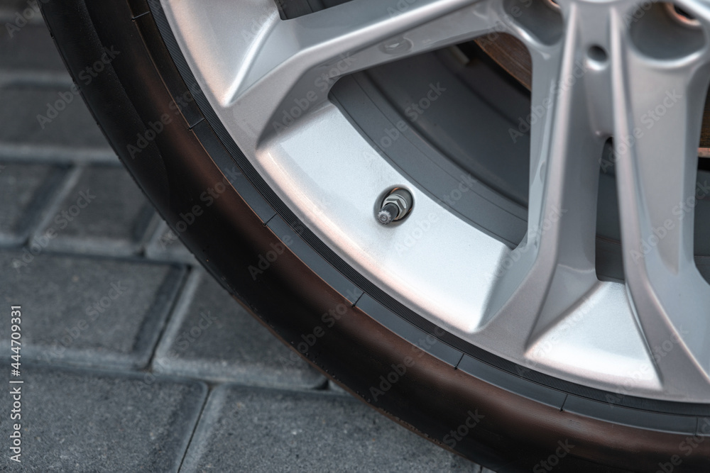 Closeup of car wheel nipple. A fragment of the wheel of the car with ...