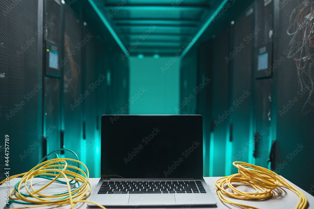Background image of opened laptop with cables in server room, network ...
