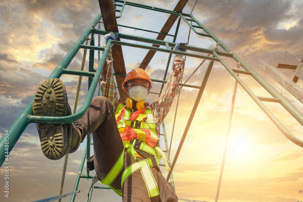 Construction worker wearing safety work at high uniform on scaffolding ...
