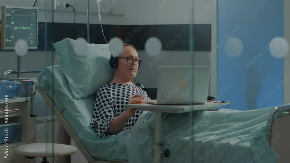 Hospital ward patient listening to music in intensive care room at ...