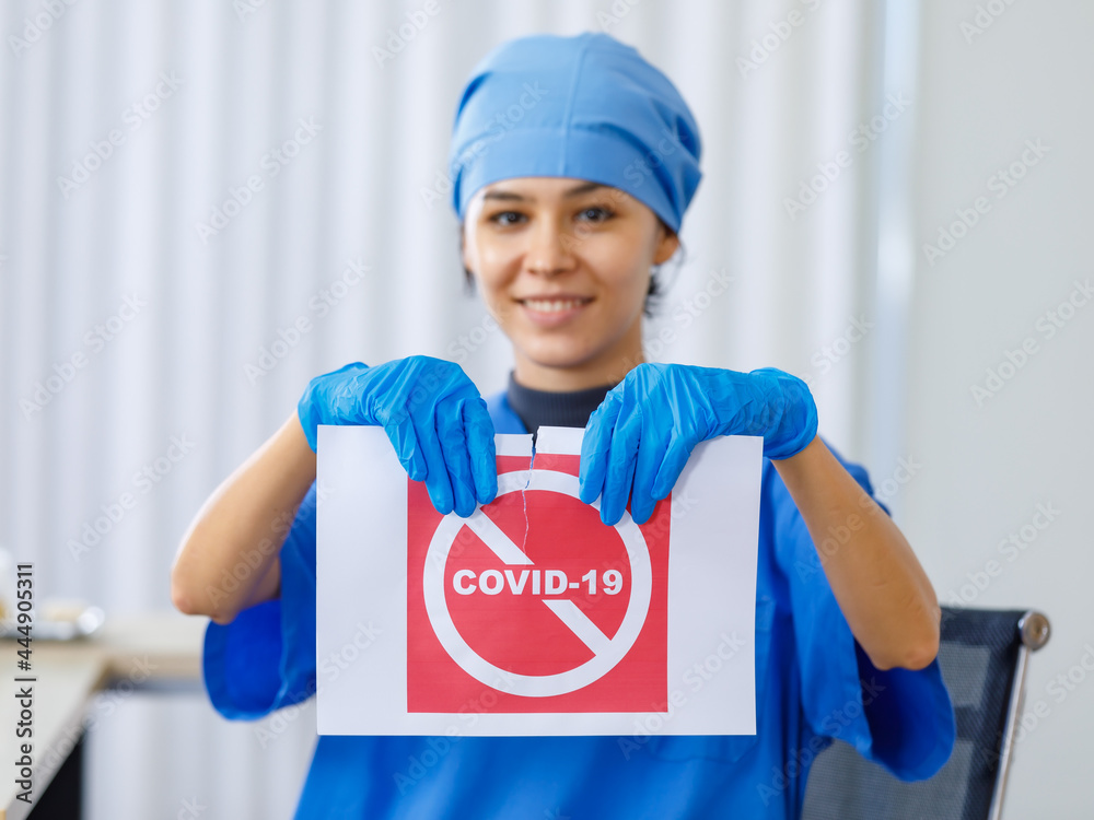 Red Covid-19 paper sign was torn apart by happy beautiful doctor in ...
