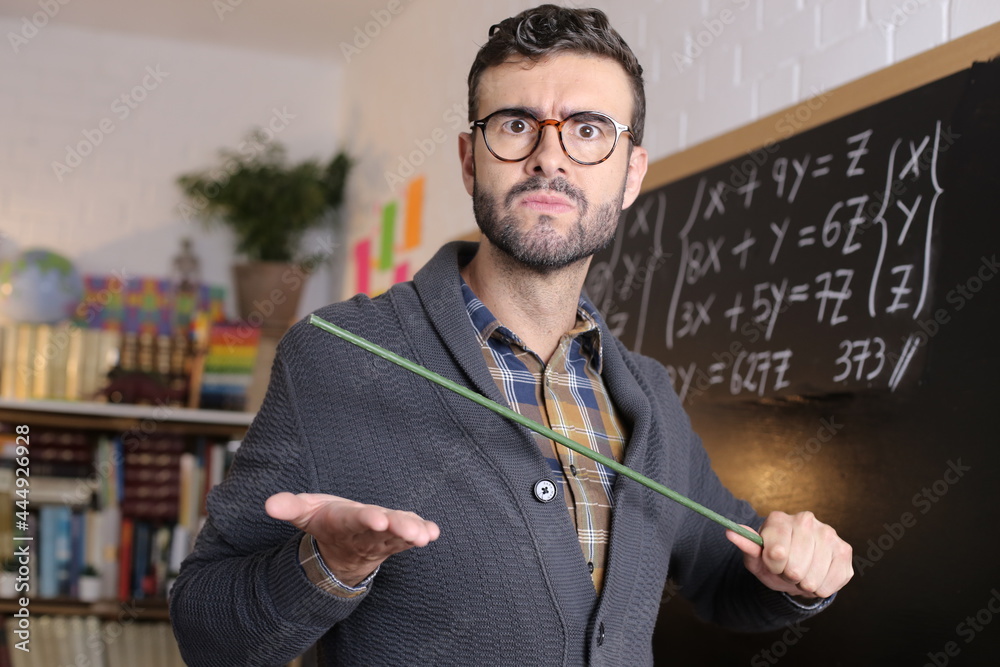 Old fashioned angry teacher holding stick in classroom Stock Photo ...