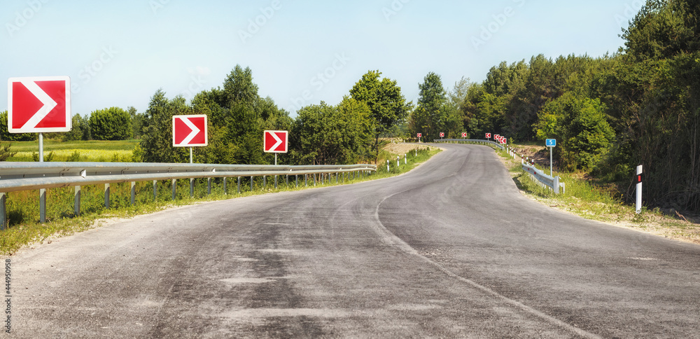 Panoramic view of winding asphalt road with traffic signs warning about ...