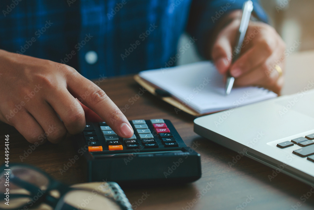 Close up man hand using a calculator to calculate the numbers and the ...
