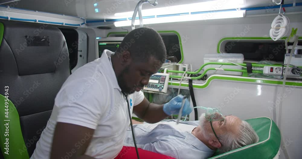 African American paramedic saving life of old man in ambulance. Medic ... African American paramedic saving life of old man in ambulance. Medic ...