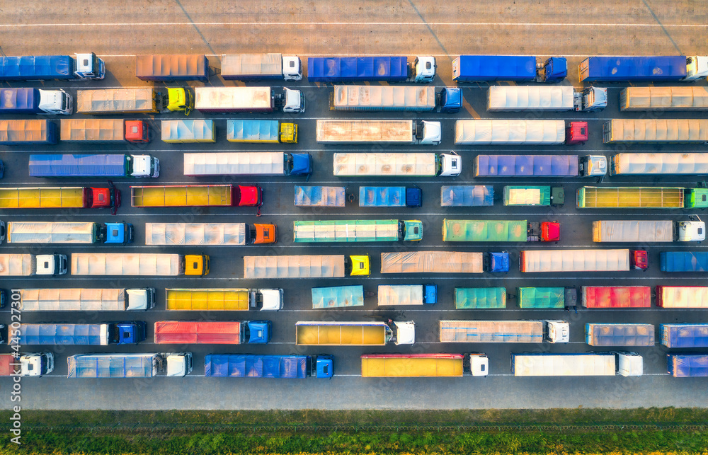 Aerial view of colorful trucks in terminal at sunset in summer. Top ...