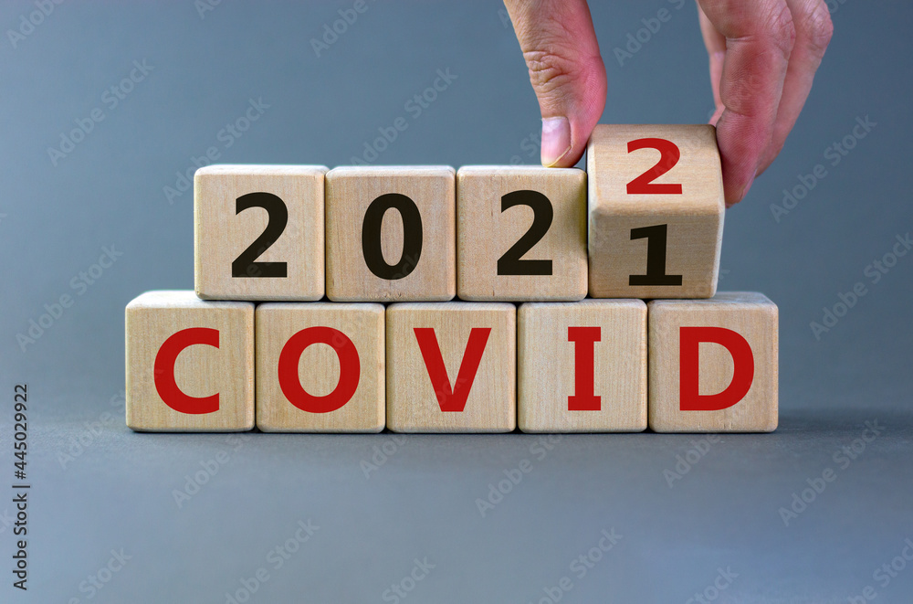 Covid-19 pandemic in 2022 symbol. Doctor turns a wooden cube and ...
