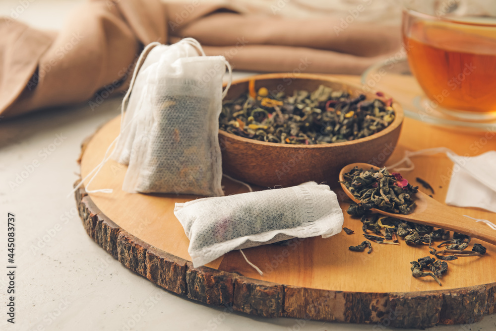 Tea bags and bowl with dry leaves on light background Stock Photo ...