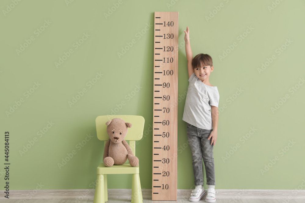 Little boy measuring height near color wall Stock Photo | Adobe Stock