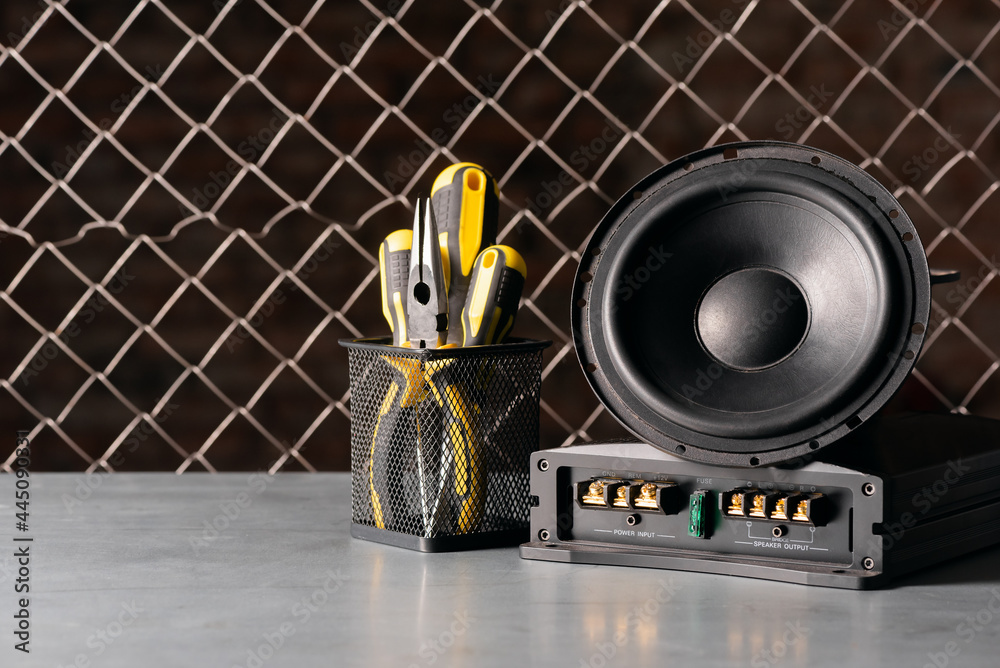 Car stereo system components and work tools on the metal workbench ...