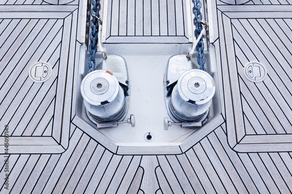 The bow is a teak deck of a luxury yacht, with stainless steel winches ...