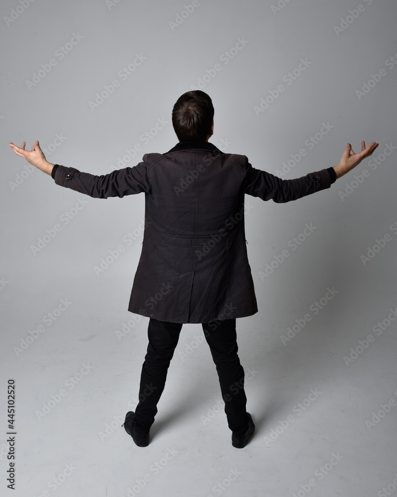 Full length portrait of a brunette man wearing black leather coat ...