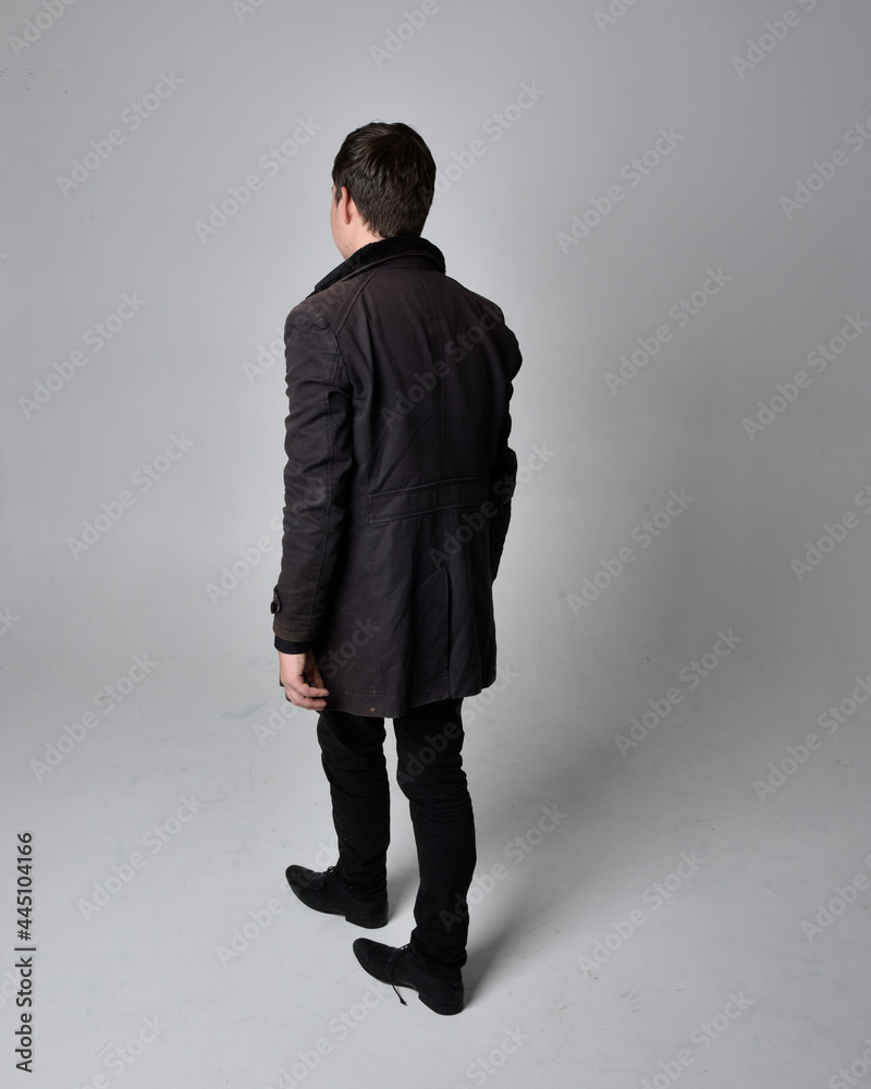 Full length portrait of a brunette man wearing black leather coat ...