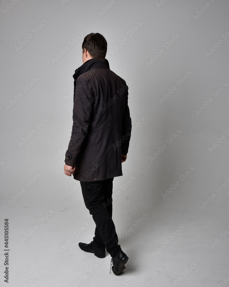 Full length portrait of a brunette man wearing black leather coat ...