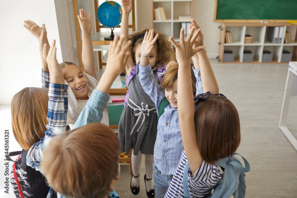 Group of enthusiastic children so glad to be back to school standing in ...
