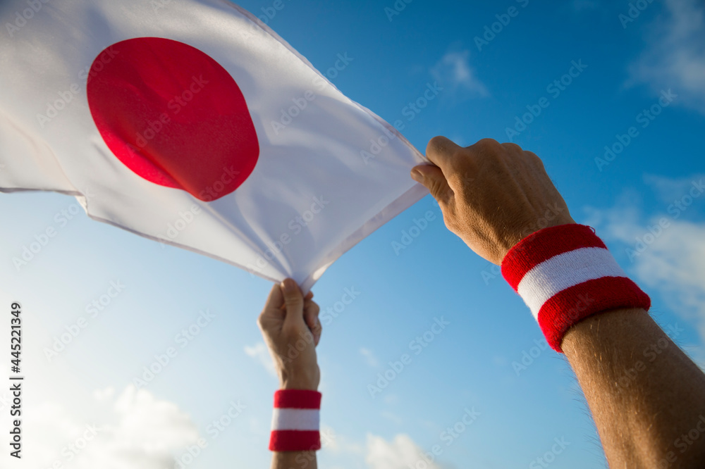 Hands with Japan red and white wristband holding a Japanese flag waving ...