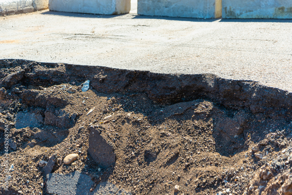 The collapse of the road. The road is blocked by concrete blocks. Stock ...