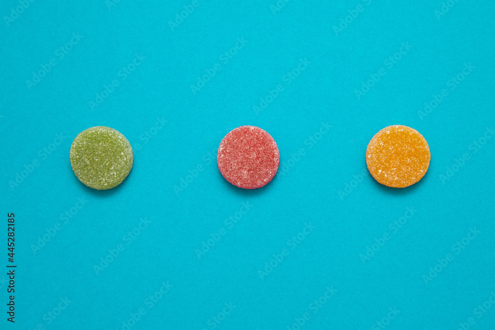 Colored round gummy candies isolated on blue background with copy space ...