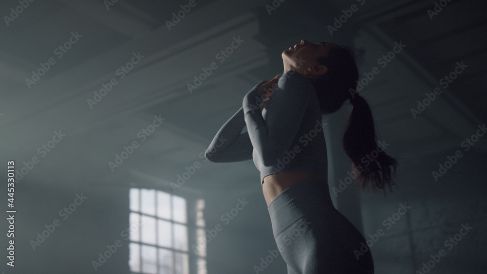 Girl performing exercises to warm up neck. Muscular woman stretching ...