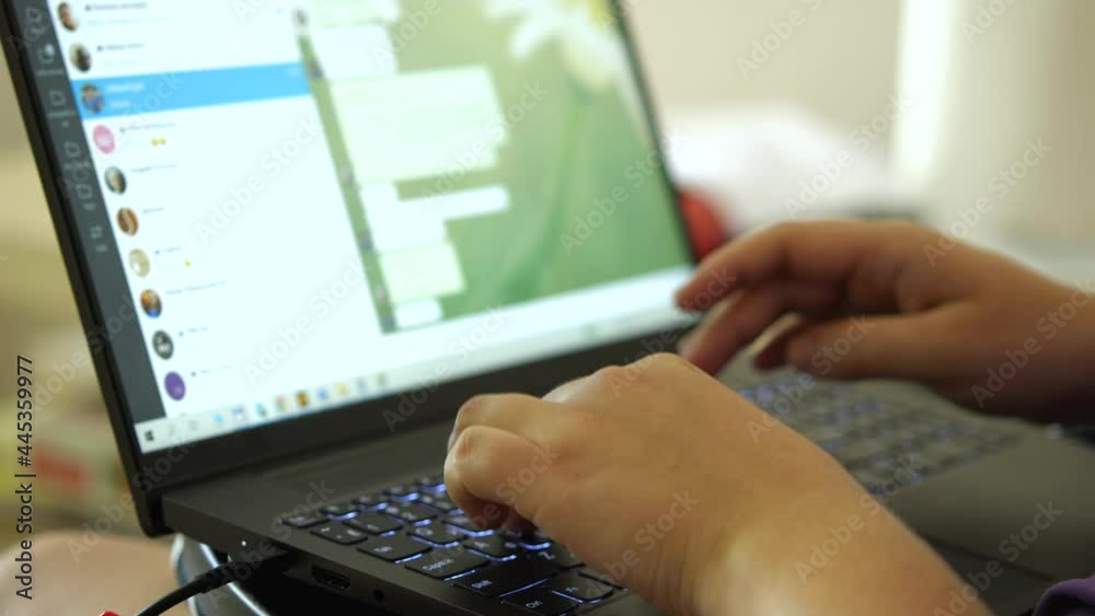 Close-up of female hands typing on a laptop keyboard. The messenger is ...