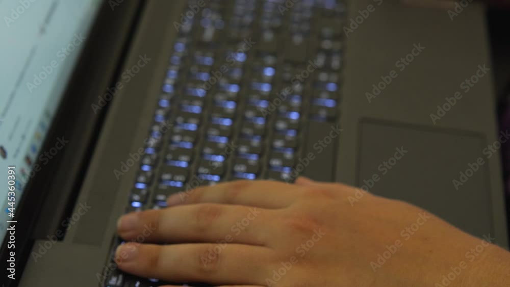 Laptop keyboard with a female hand. Top view. The camera pulls away and ...