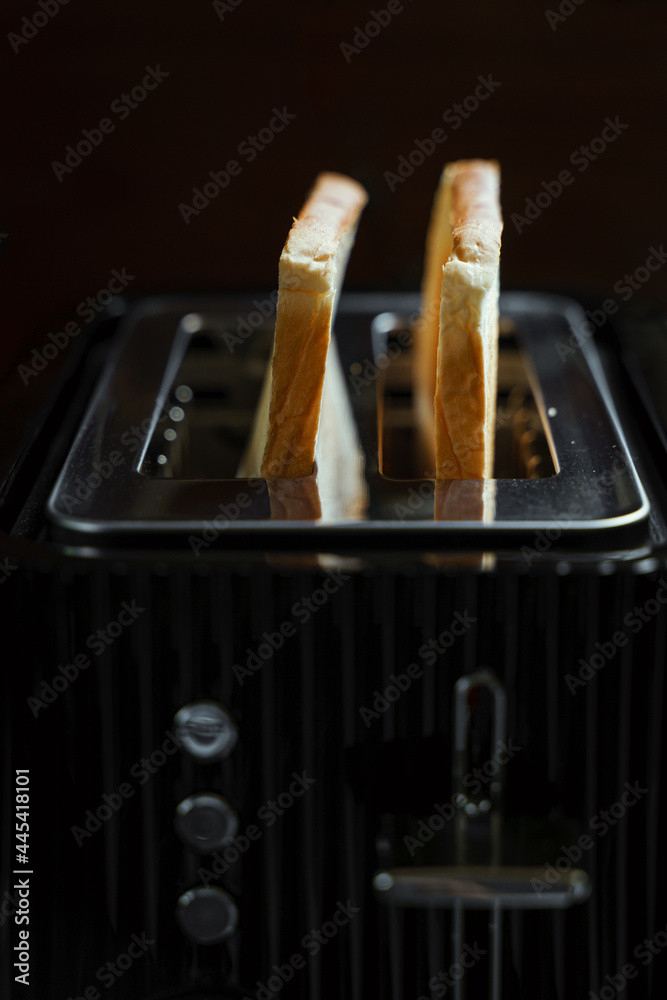 Toasted bread popping up from a black retro toaster, closeup view Stock ...