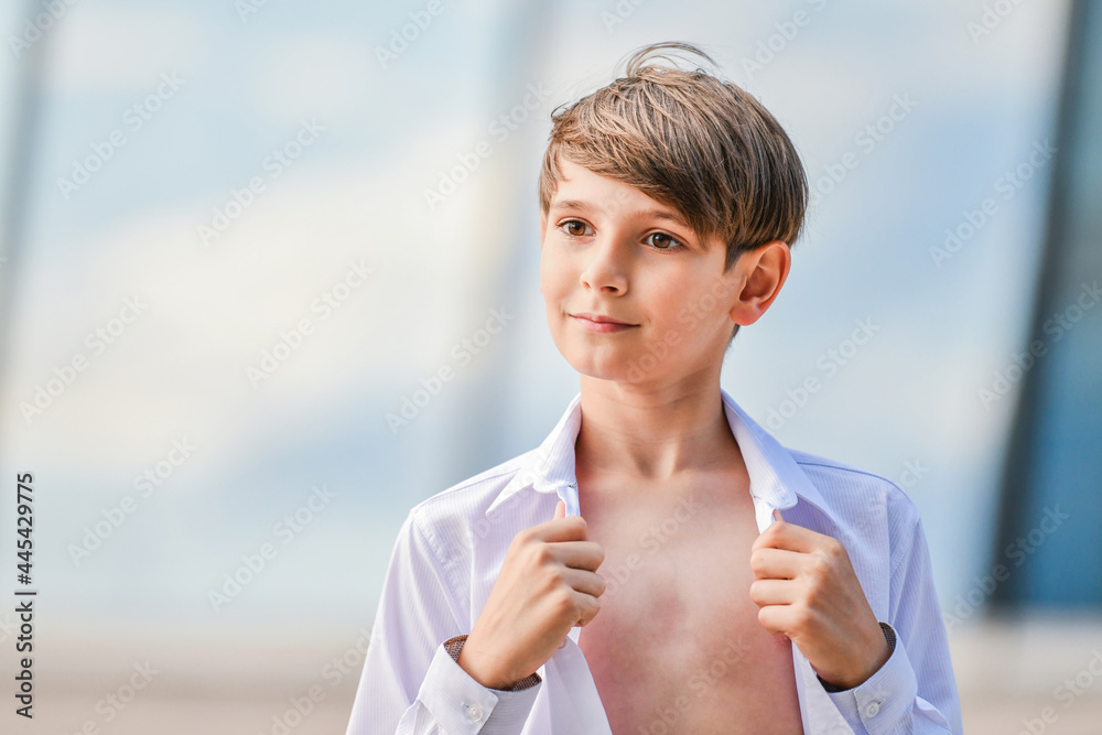 Portrait of a happy boy in an unbuttoned shirt on summer sky background ...