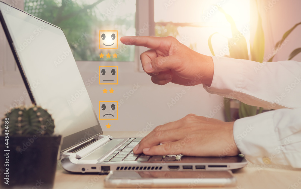 A man uses the laptop and chooses a face smile emoticon to show on the ...