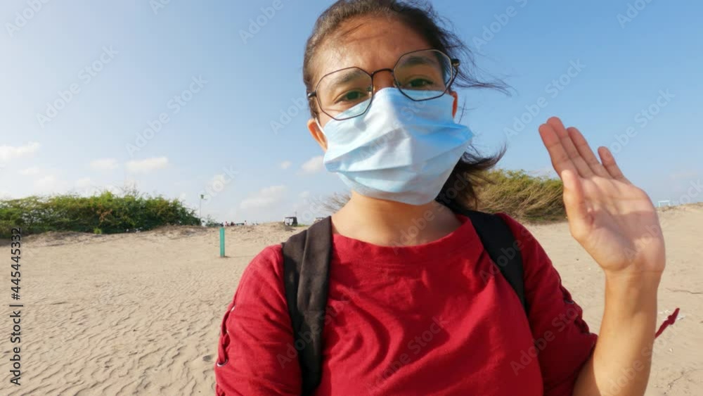 Portrait of young Indian woman vlogger vlogging on beach while wearing ...