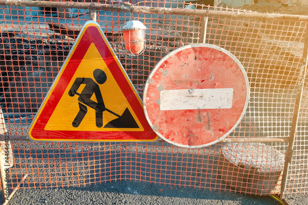 Fencing with road signs warning of construction work. Road works and ...