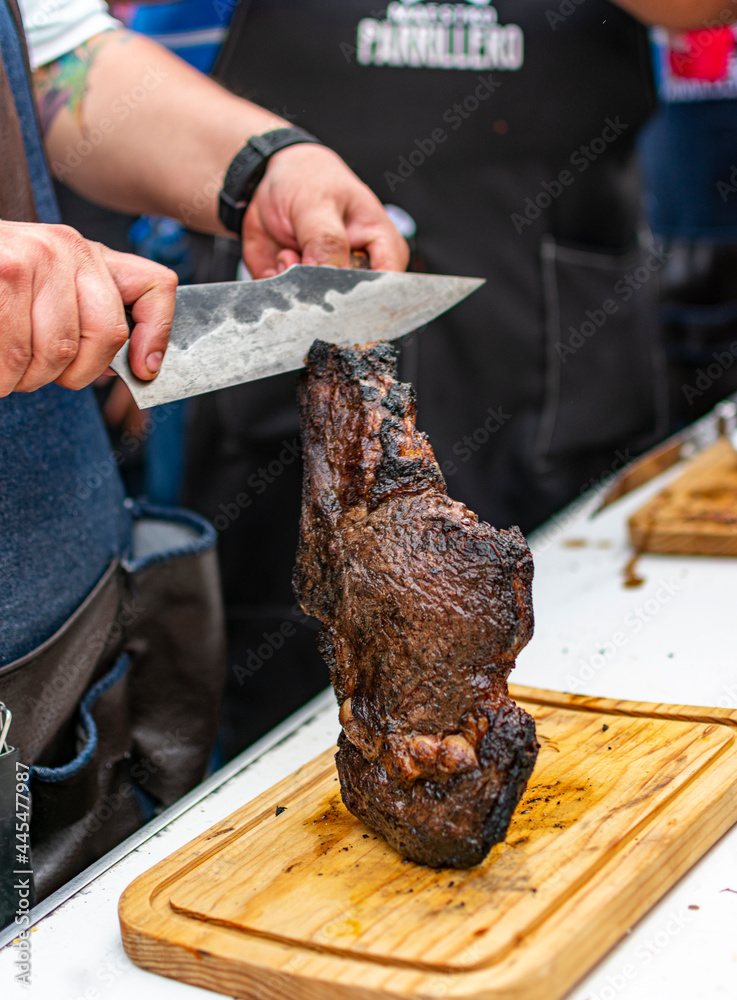 corte asado directo al carbón. cowboy asado cavernícola. manos cortando ...