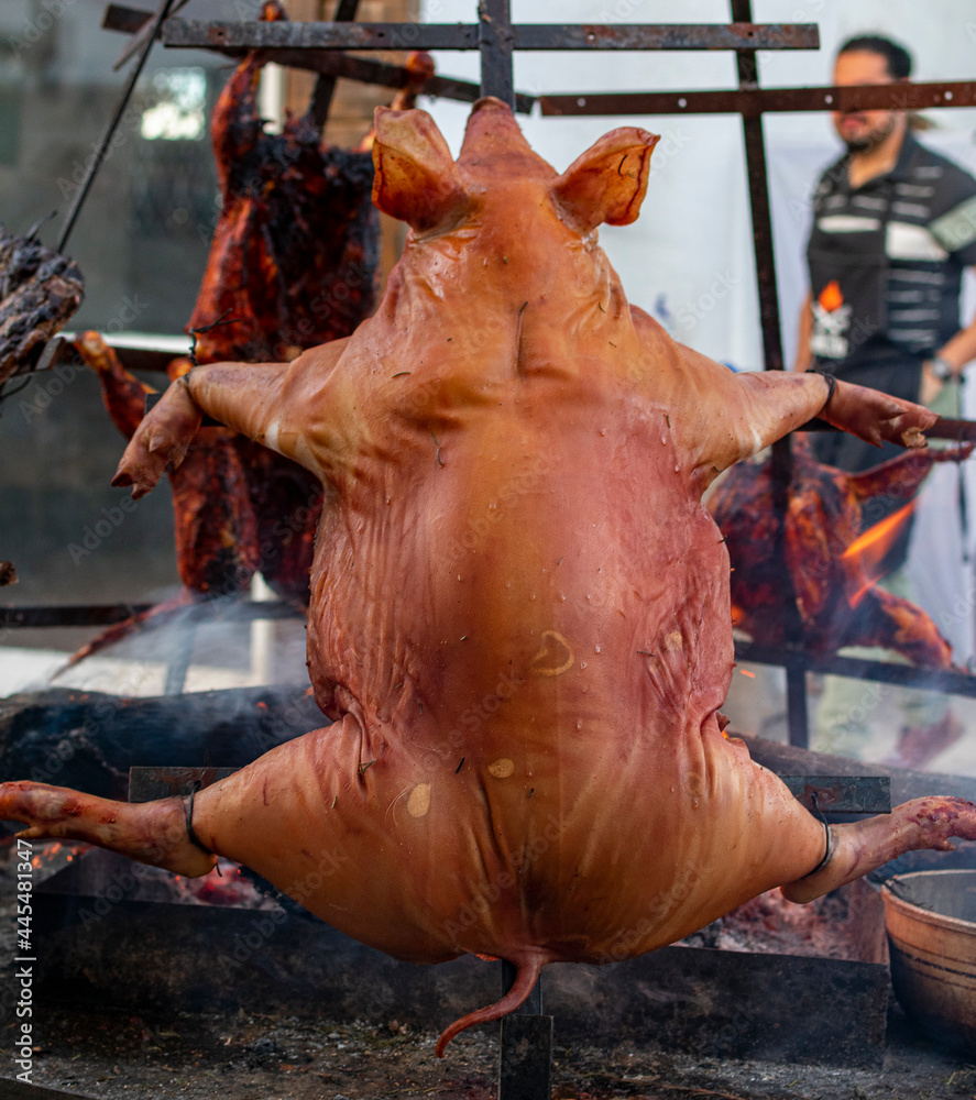Foto de cerdo asado al carbón en asador de cruz. cerdo ahumado al ...