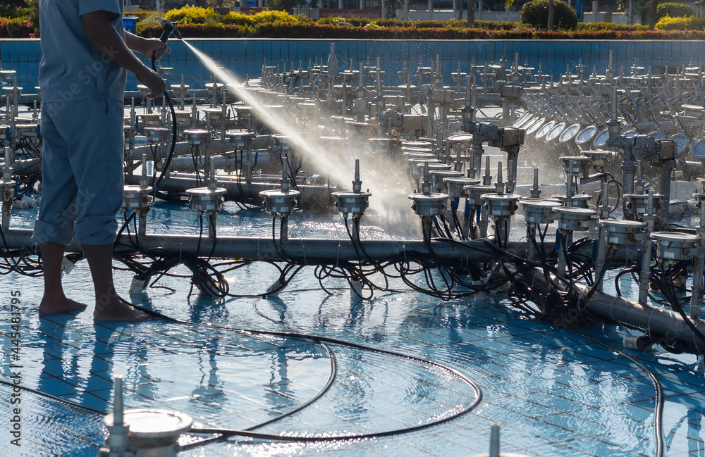 Man using electric powered pressure washer to power wash Old water pump ...