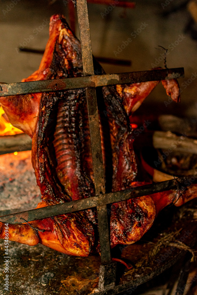 Foto de cerdo asado al carbón en asador de cruz. cerdo ahumado al ...