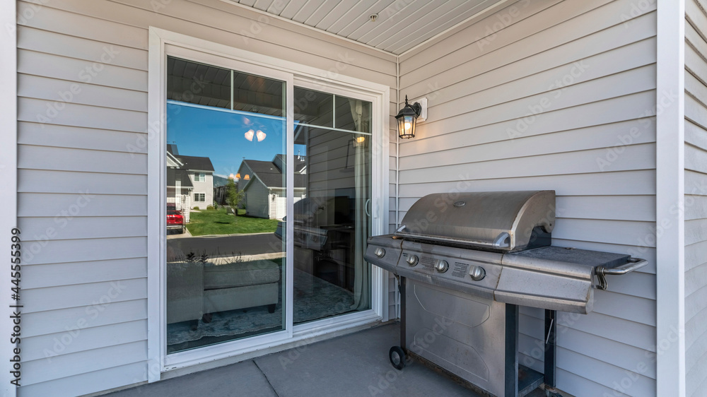 Pano Exterior of a house with a sliding glass door and vinyl sidings ...